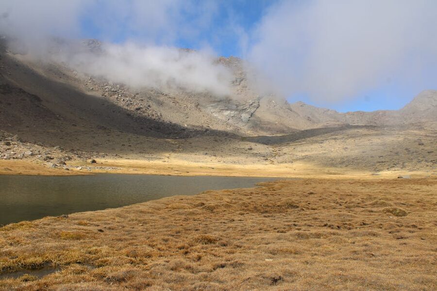 Alpine lake surrounded by misty mountains in Trevelez Sierra Nevada