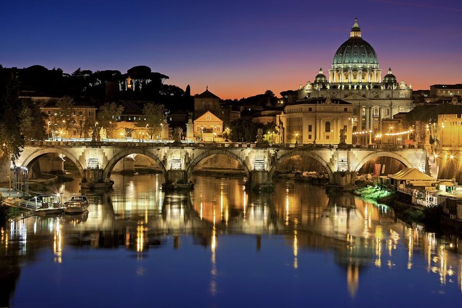 St. Peter's Basilica and Sant Angelo Bridge over Tiber River sunset