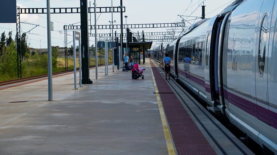 Passengers waiting beside a high-speed train at Barcelona station
