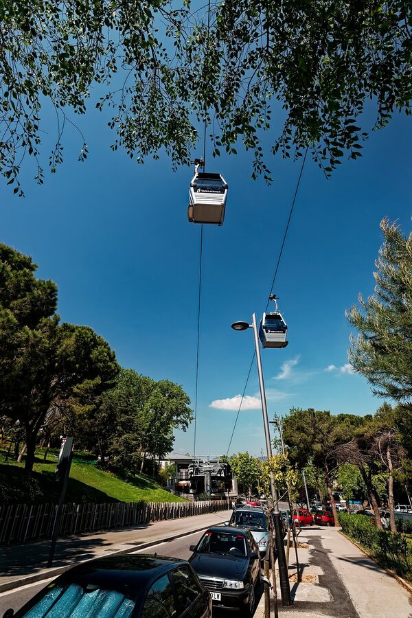 Telefèric de Montjuïc gondolas above wooded Montjuïc hill