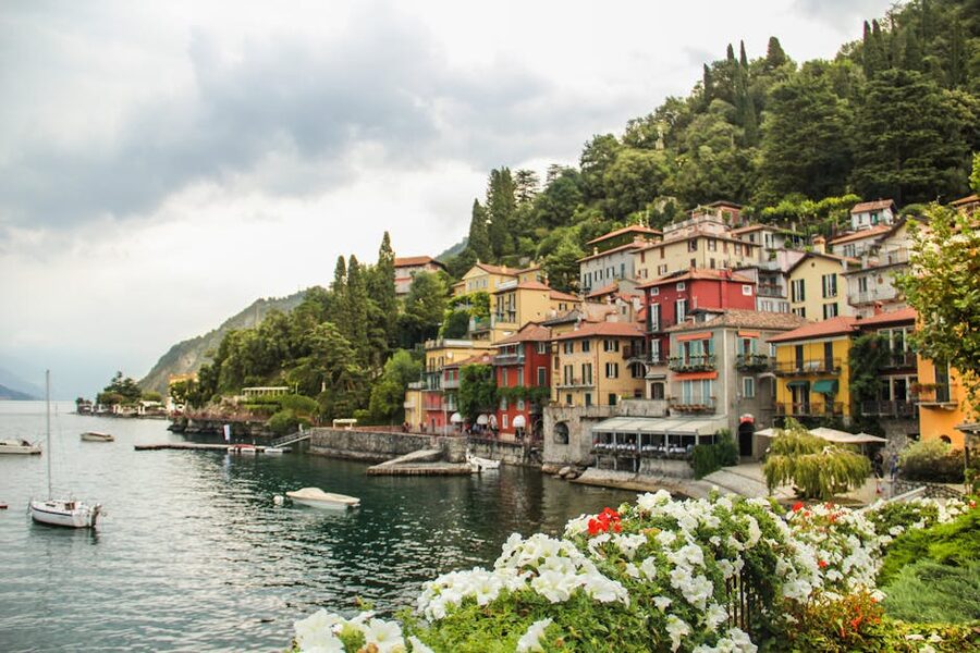 Varenna village colorful houses and sailboats against lush hills on Lake Como
