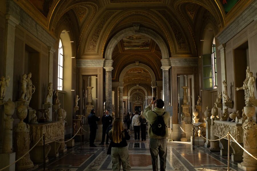 Visitors walking through the Pio Clementino sculpture gallery at the Vatican Museums
