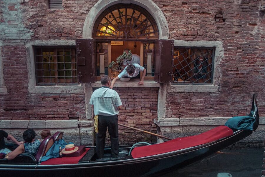 A gondolier passing a Venetian brick building on a canal