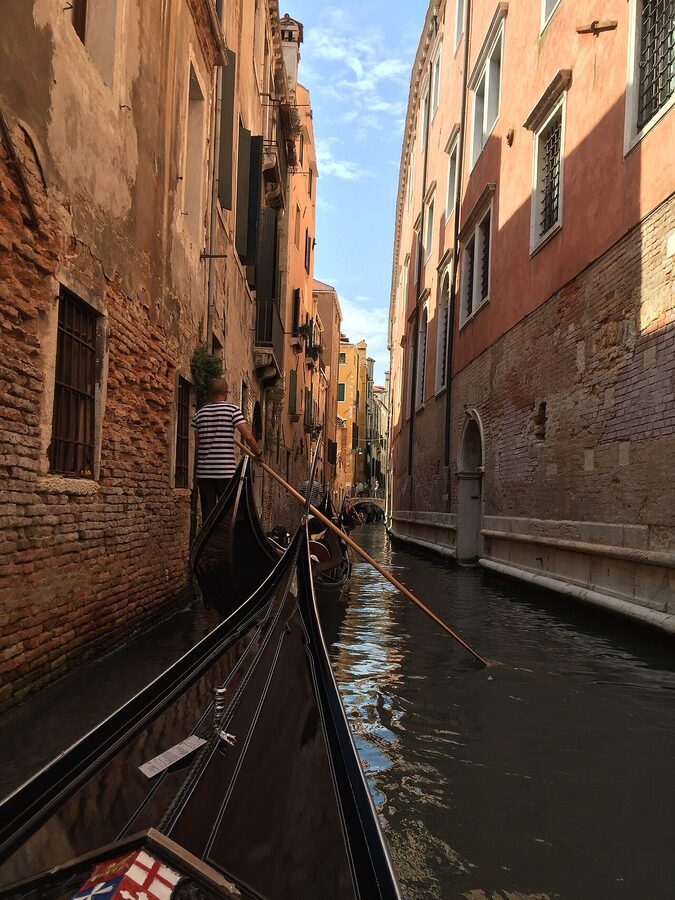 A gondola passing through a tight Venetian side canal