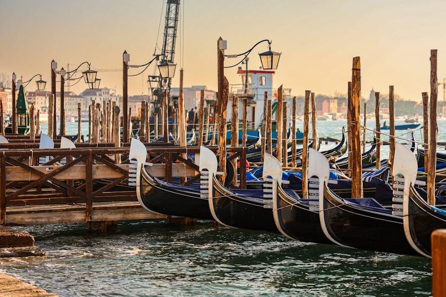 Gondolas moored together at sunrise on a Venice canal