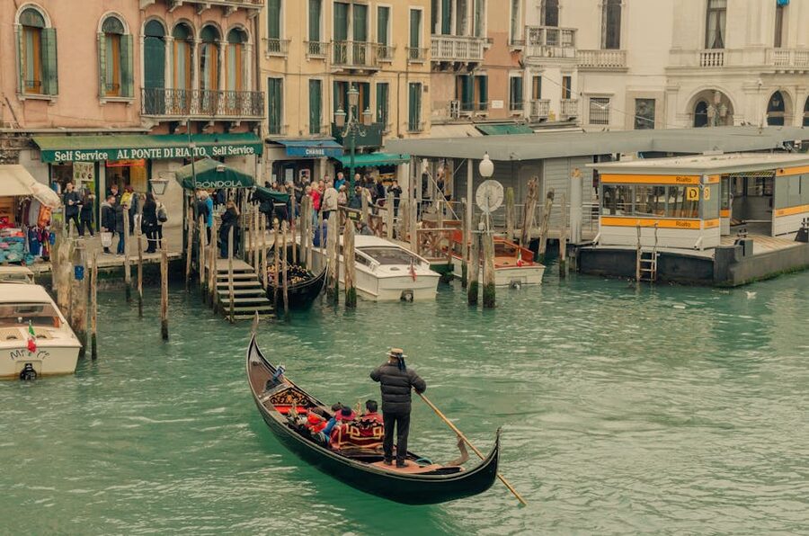 A gondolier maneuvering his gondola near Rialto Bridge in Venice