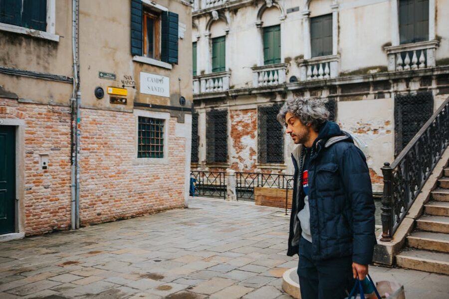 A man walking through a quiet Venice courtyard