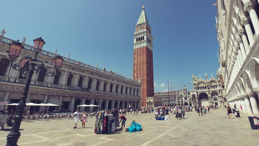 Tourists crossing Piazza San Marco in Venice with the Doge's Palace and Campanile