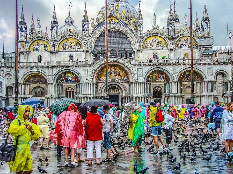 A person in a yellow raincoat walking near St Mark's in the rain