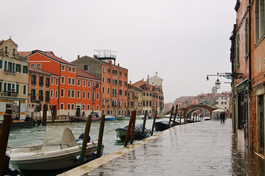 A quiet Venetian canal under a grey, rainy sky