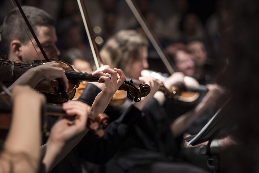 Orchestra violinists tuning before a performance