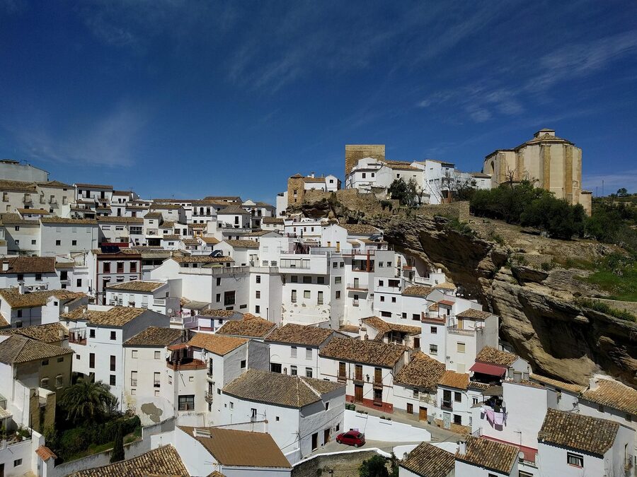 People walking through Setenil under the rock overhang